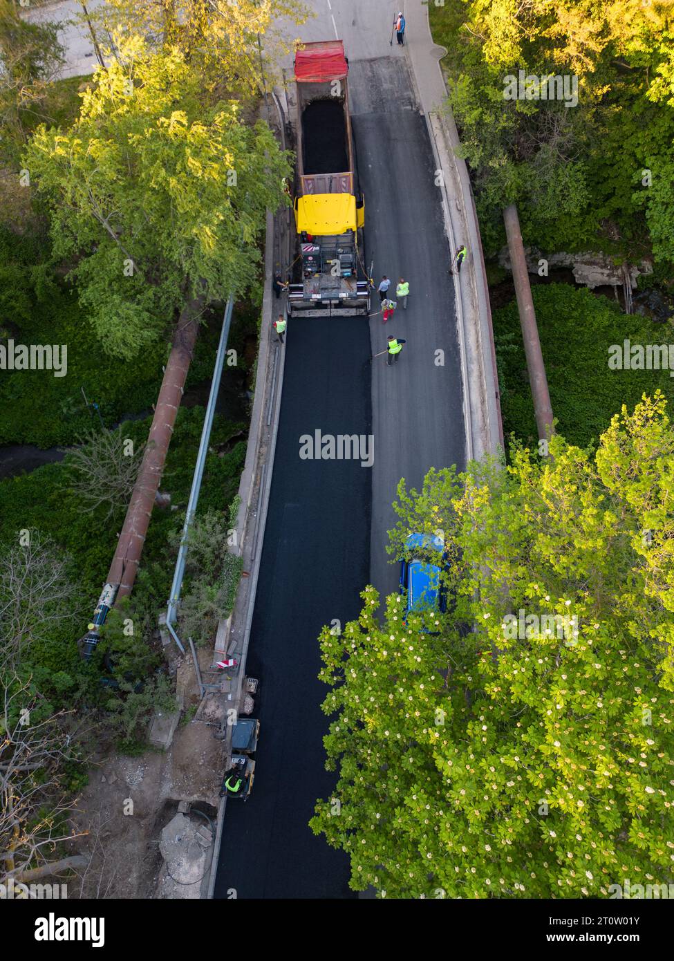 Aerial view of the construction of a new road as asphalt pavers ...