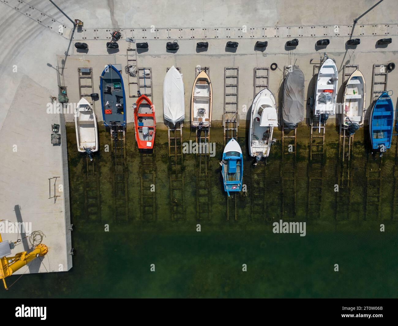 aerial top down view of a serene dock in the sea, with several fishing ...