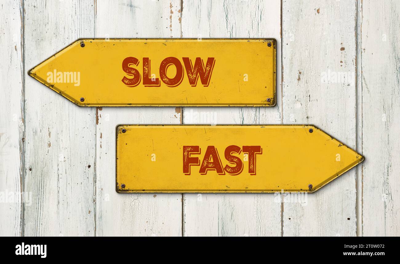 Direction signs on a wooden wall - Slow or Fast Stock Photo - Alamy