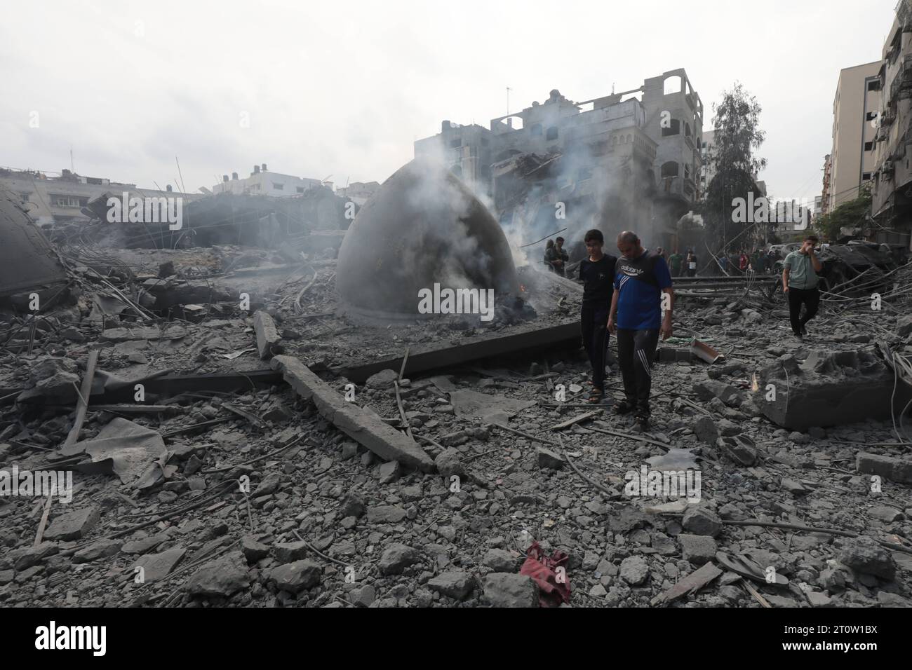 Palestinians inspect the damage following an Israeli airstrike on the ...