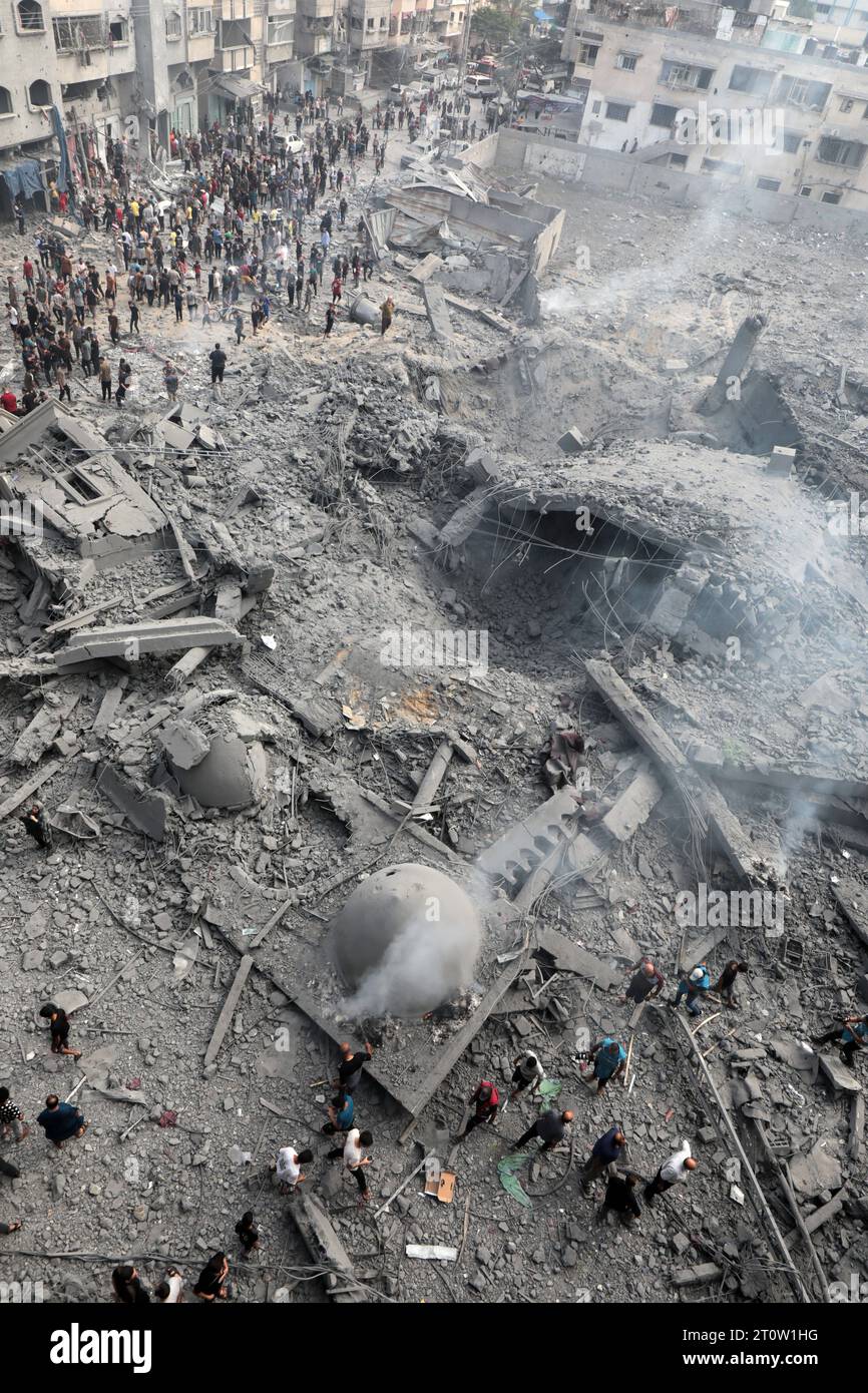 Palestinians inspect the damage following an Israeli airstrike on the ...