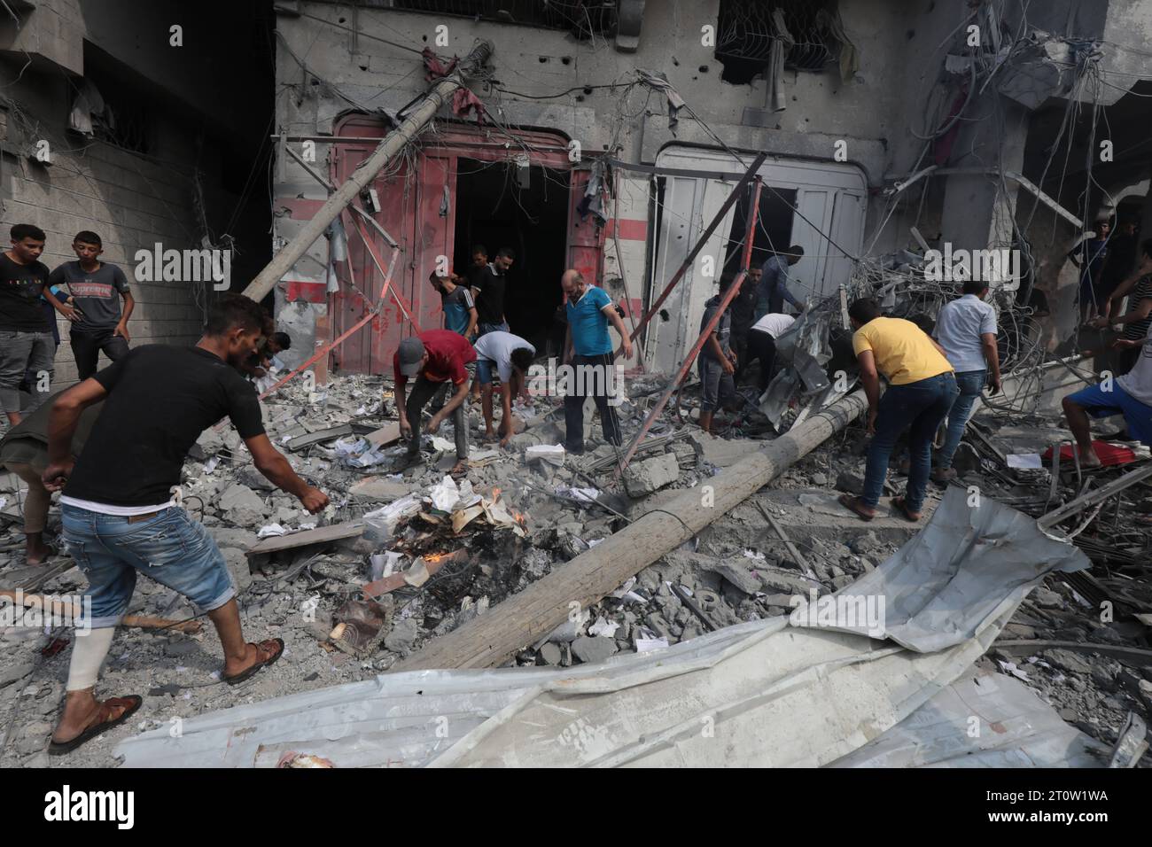 Palestinians inspect the damage following an Israeli airstrike on the ...