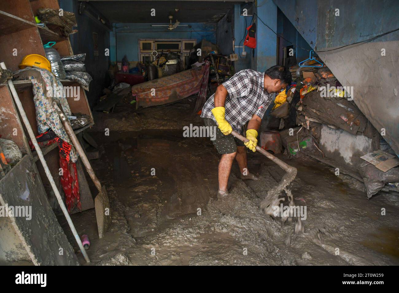 Singtam, India. 09th Oct, 2023. Sanjay Prasad removes mud and silt from ...