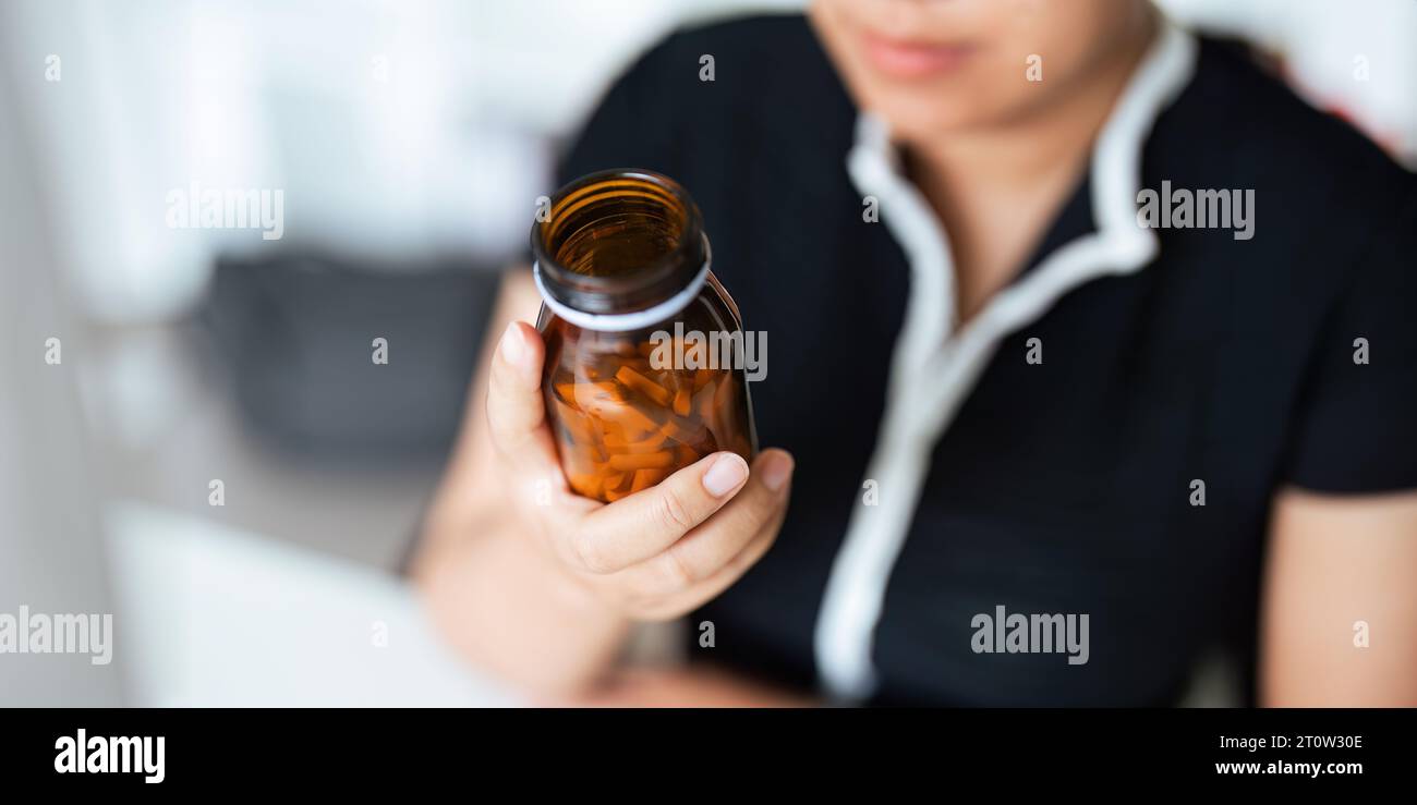 Woman hold bottle of drug tablet painkiller or vitamin supplement ...