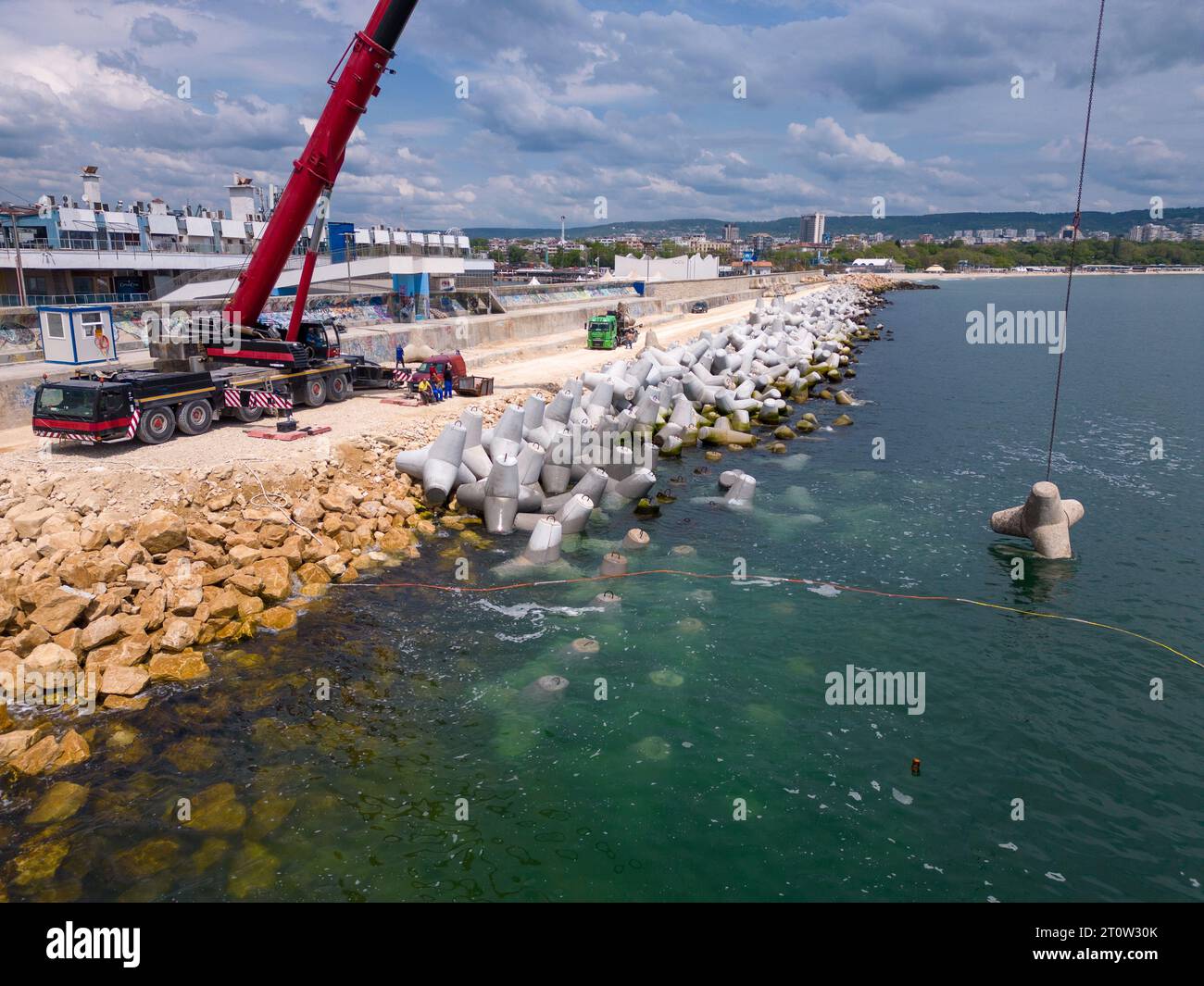 Aerial top view of breakwater construction. Bulldozer and crane on a ...