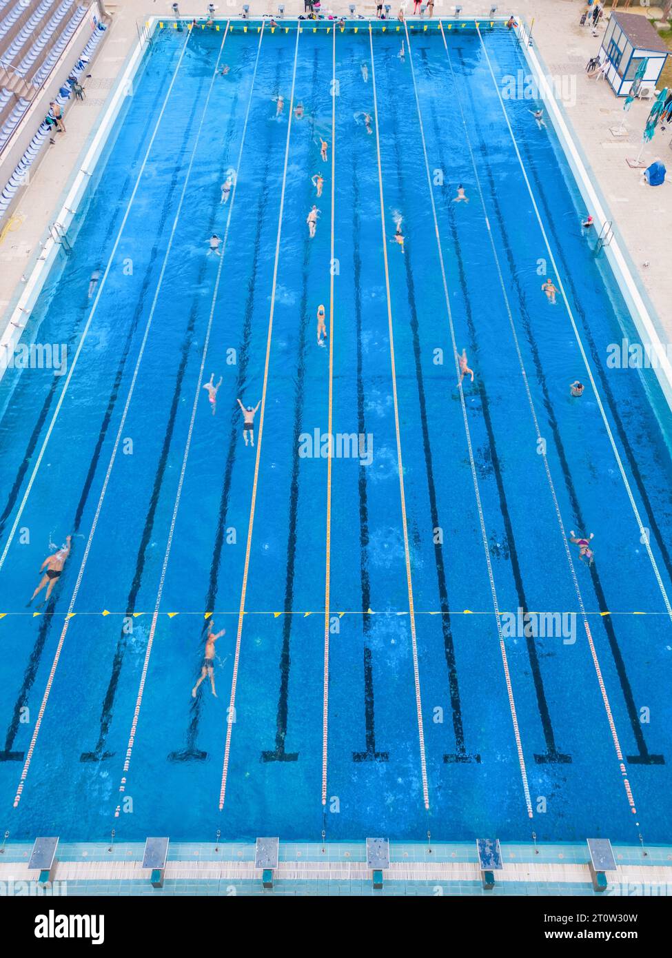 The open sports swimming pool glistened under the bright sun as people ...