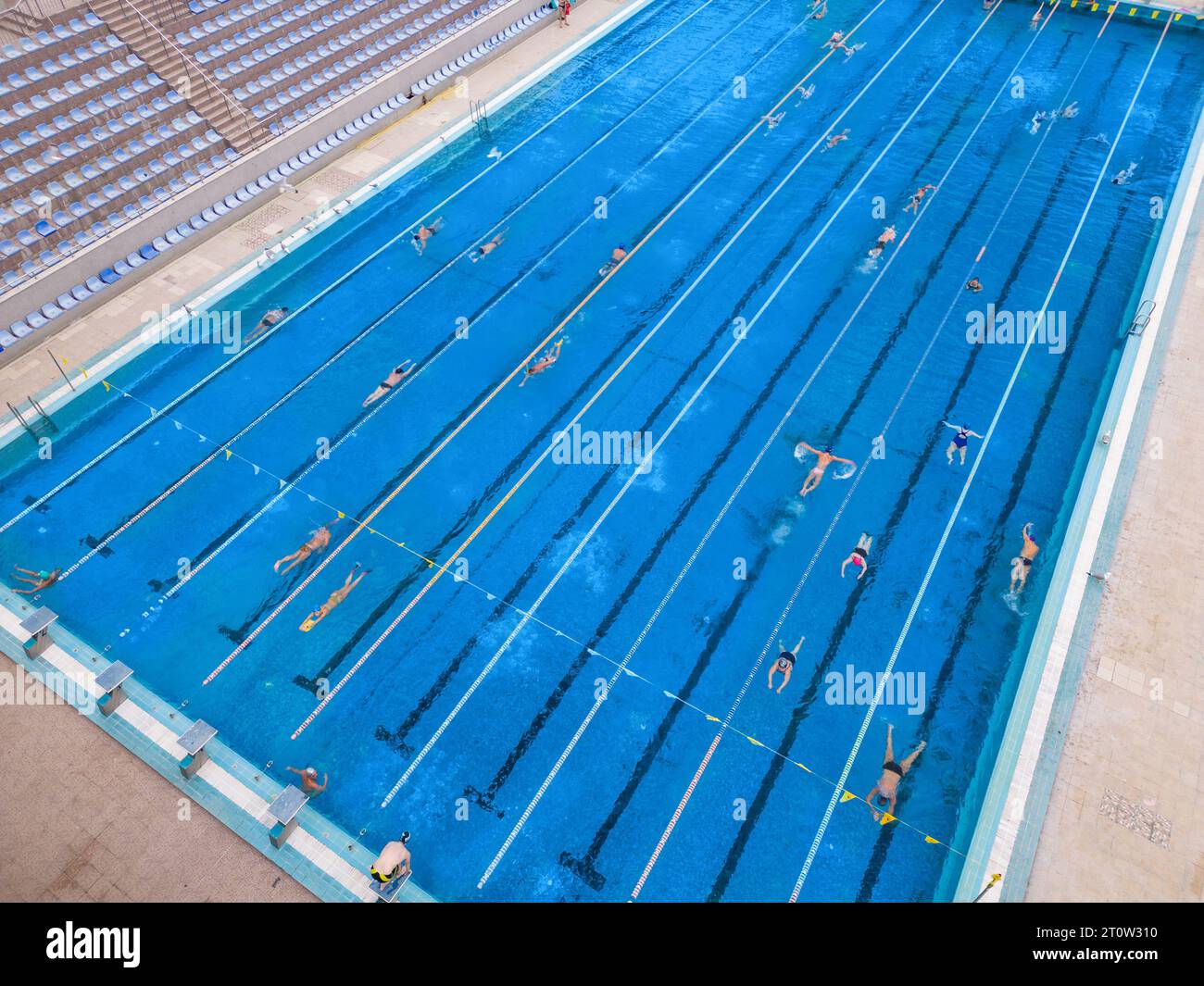 The open sports swimming pool glistened under the bright sun as people ...