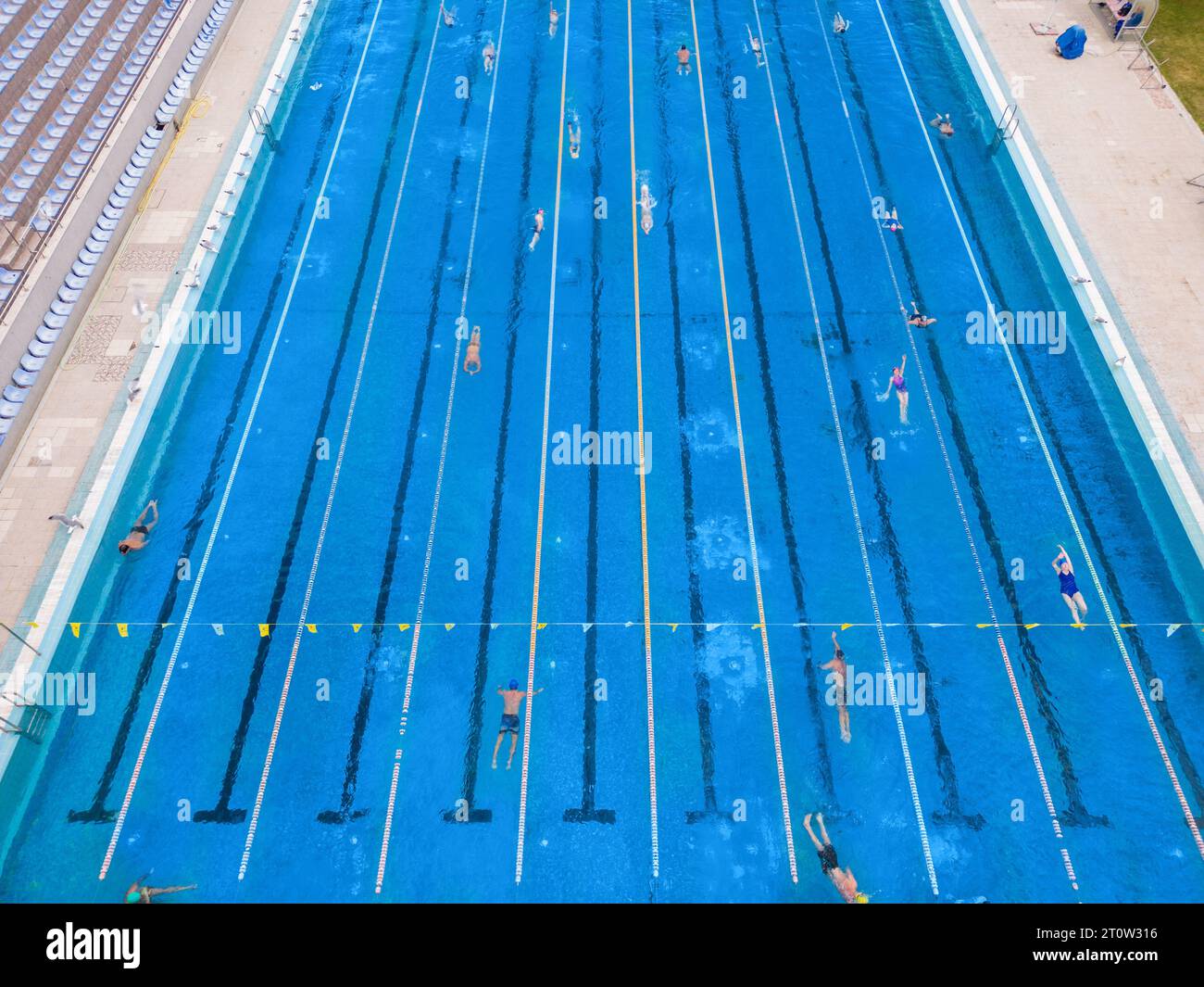 The open sports swimming pool glistened under the bright sun as people ...