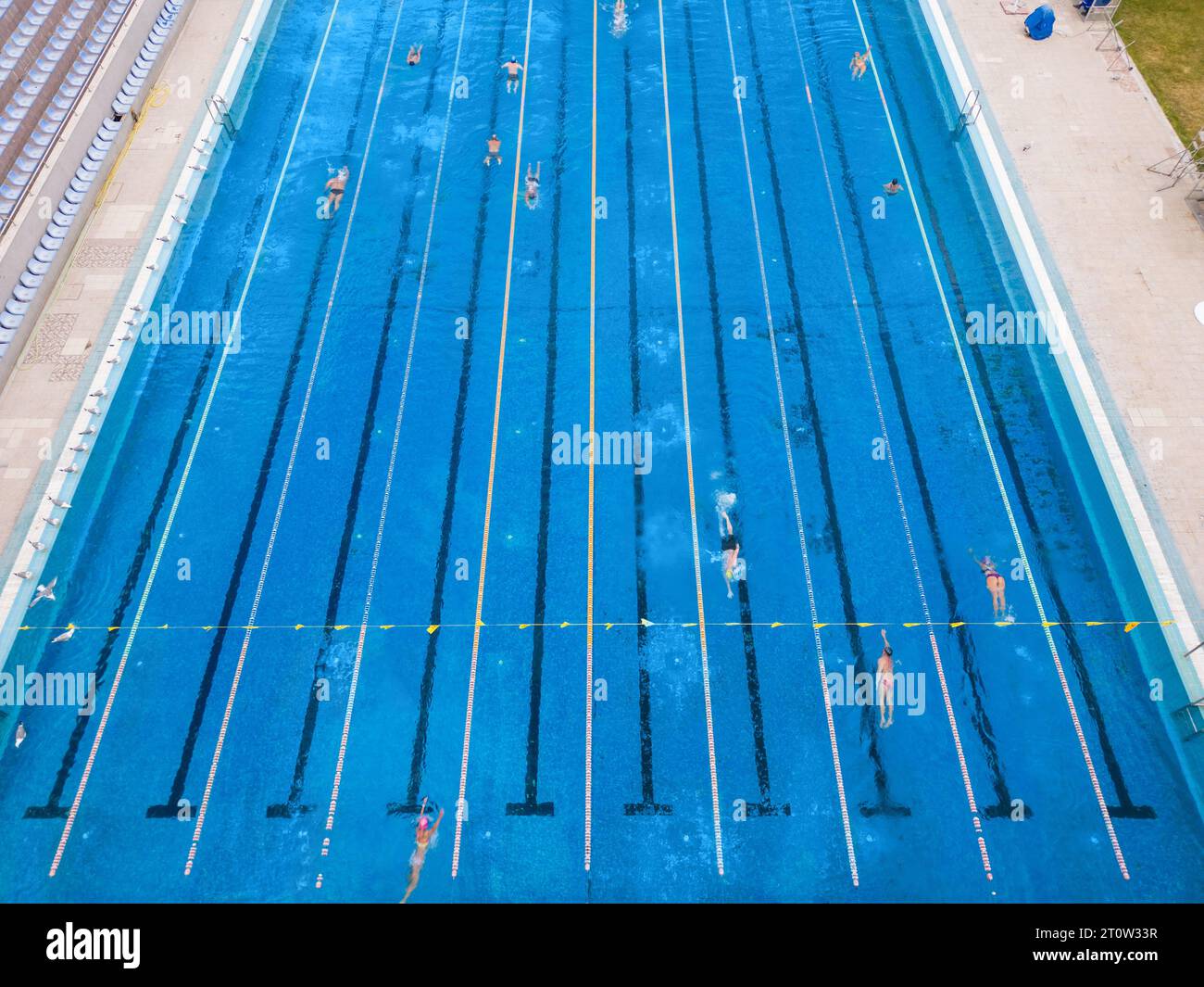 The open sports swimming pool glistened under the bright sun as people ...