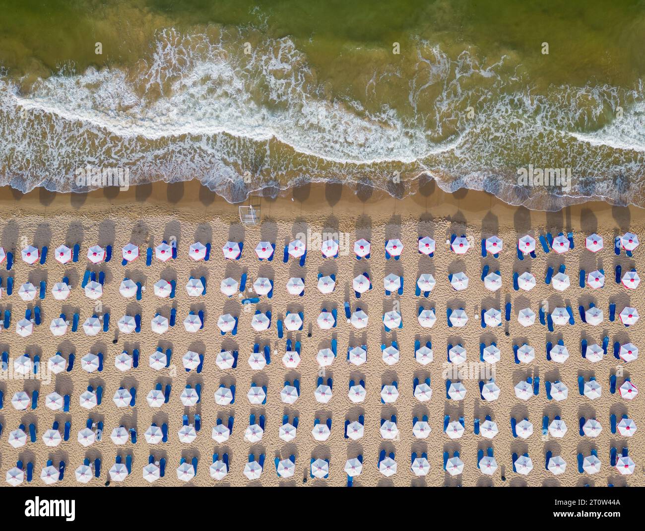 Aerial top view of an amazing empty sand beach with straw beach ...