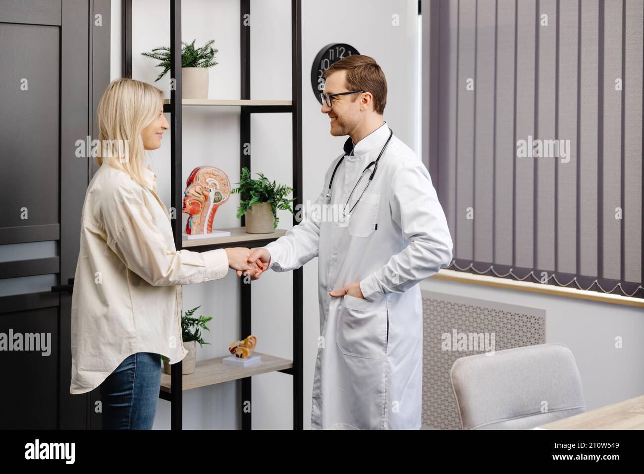 Vertical shot of young happy cheerful medical worker therapist in white ...