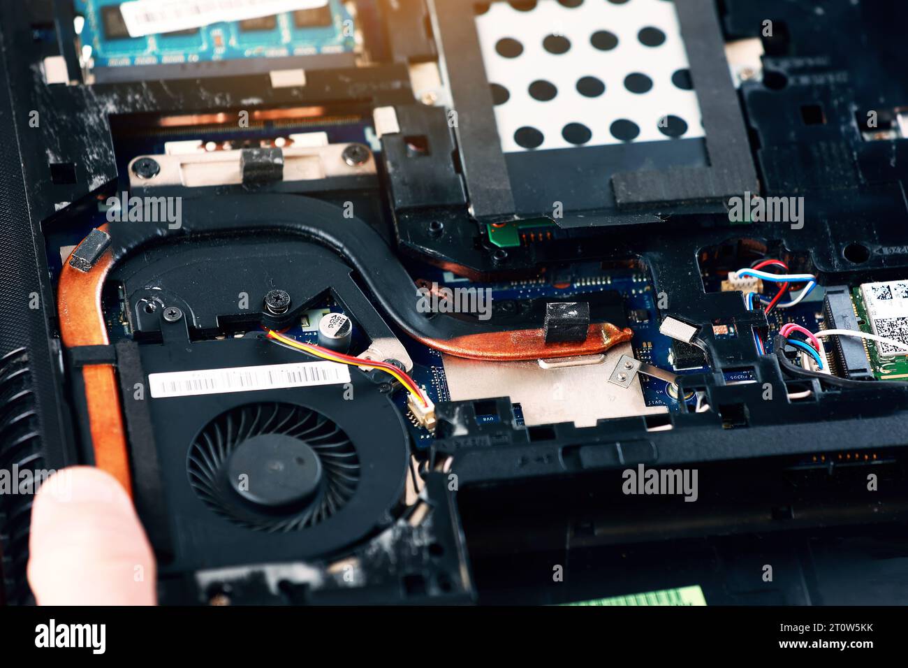 Fixing laptop. Repairman holds cooling fan and repairs from overheating ...