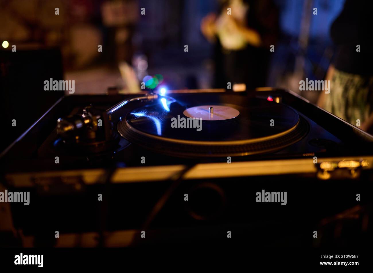 A vinyl record spins on a turntable under the gentle glow of a ...