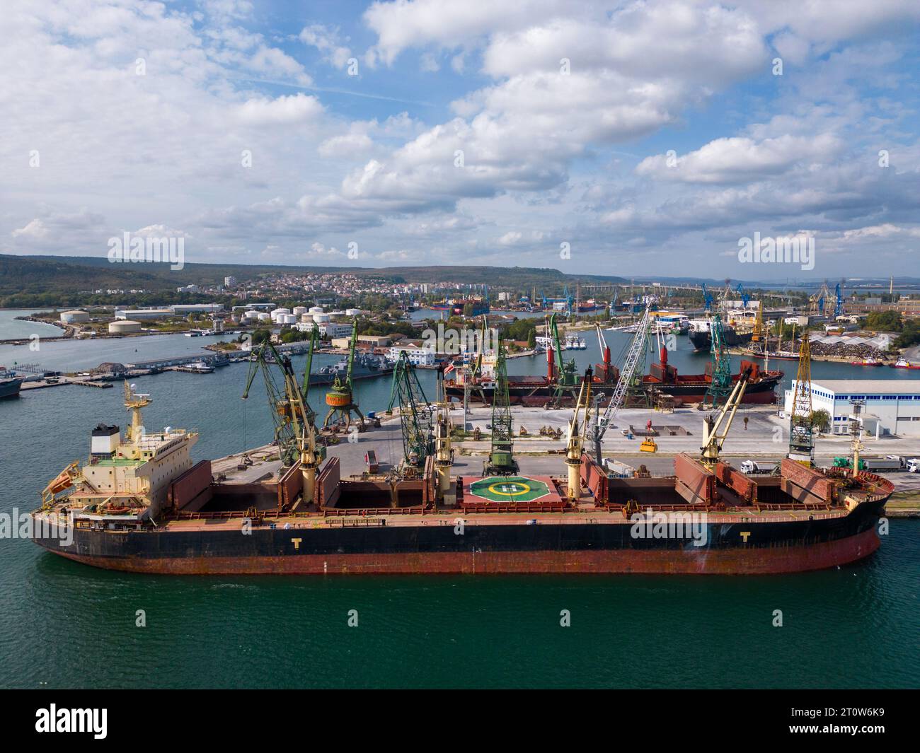 aerial view of a bustling seaport, where a massive cargo ship, a bulk ...