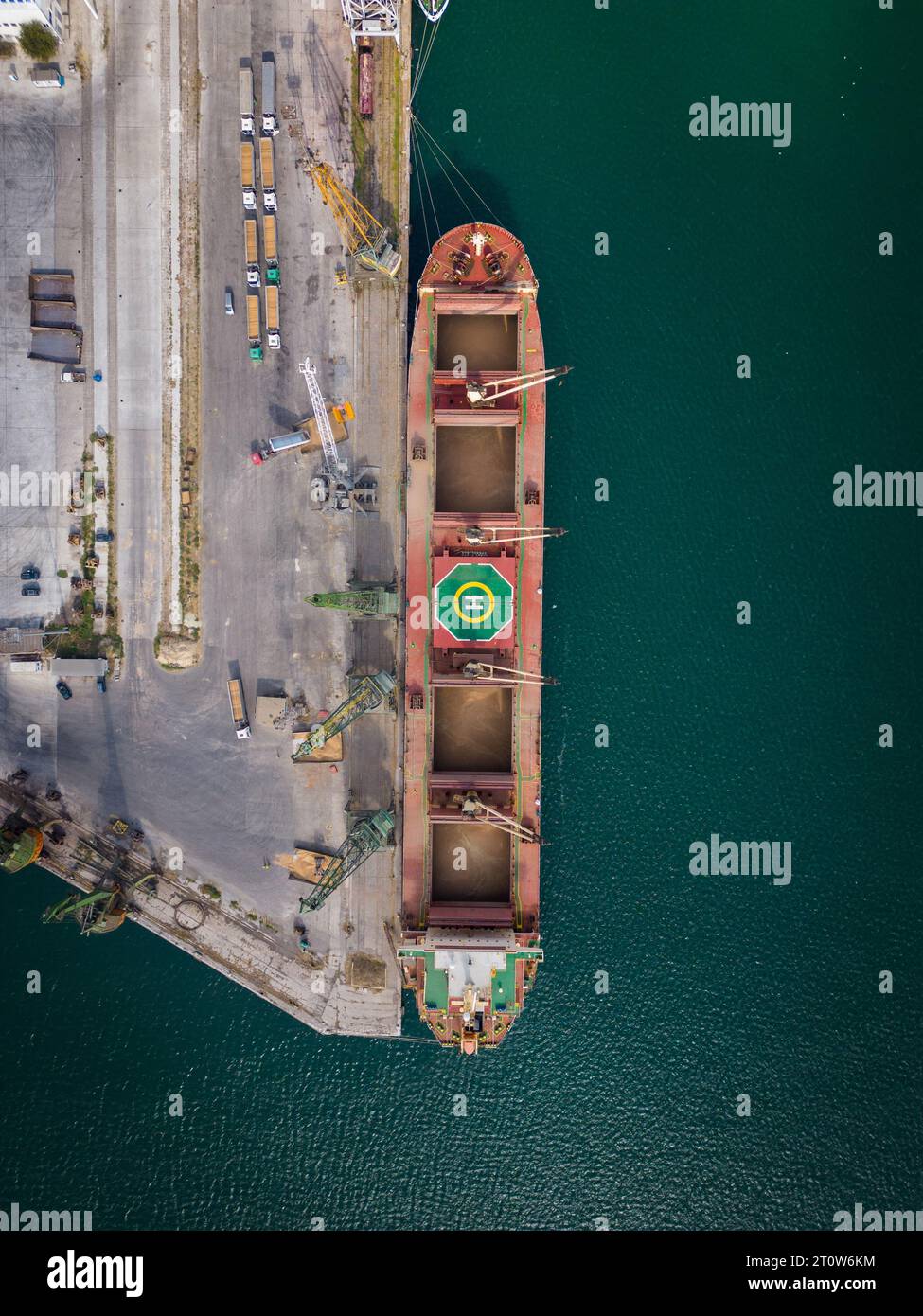 aerial view of a bustling seaport, where a massive cargo ship, a bulk ...