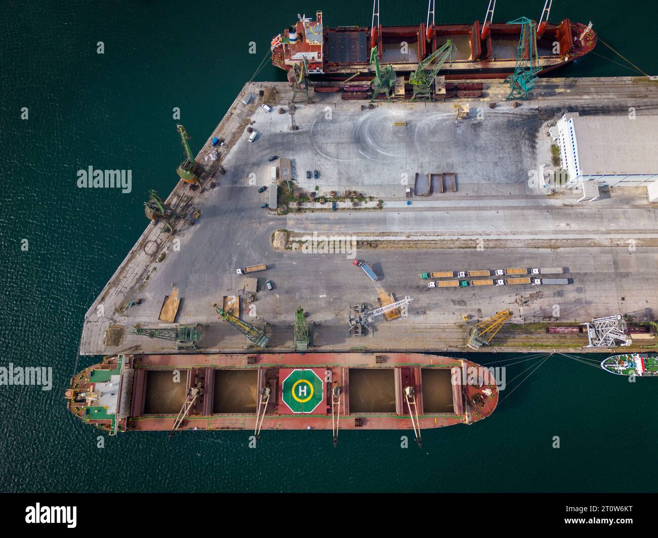 aerial view of a bustling seaport, where a massive cargo ship, a bulk ...