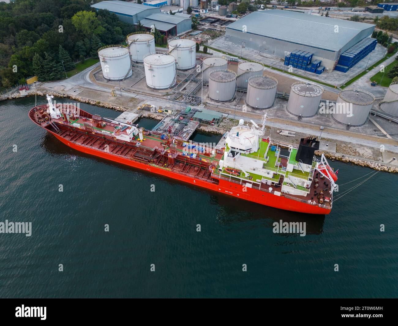 Tanker ship refueling at an oil terminal with storage silo's in the ...