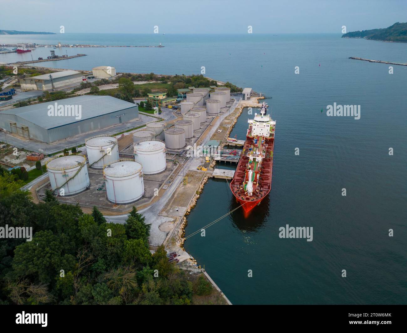 Tanker ship refueling at an oil terminal with storage silo's in the ...