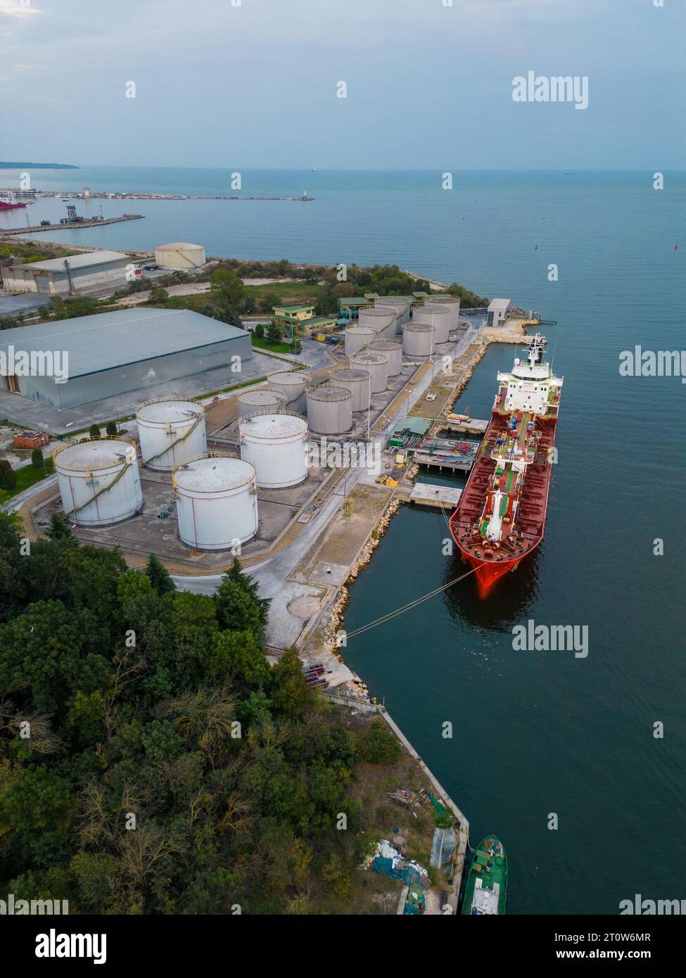 Tanker ship refueling at an oil terminal with storage silo's in the ...