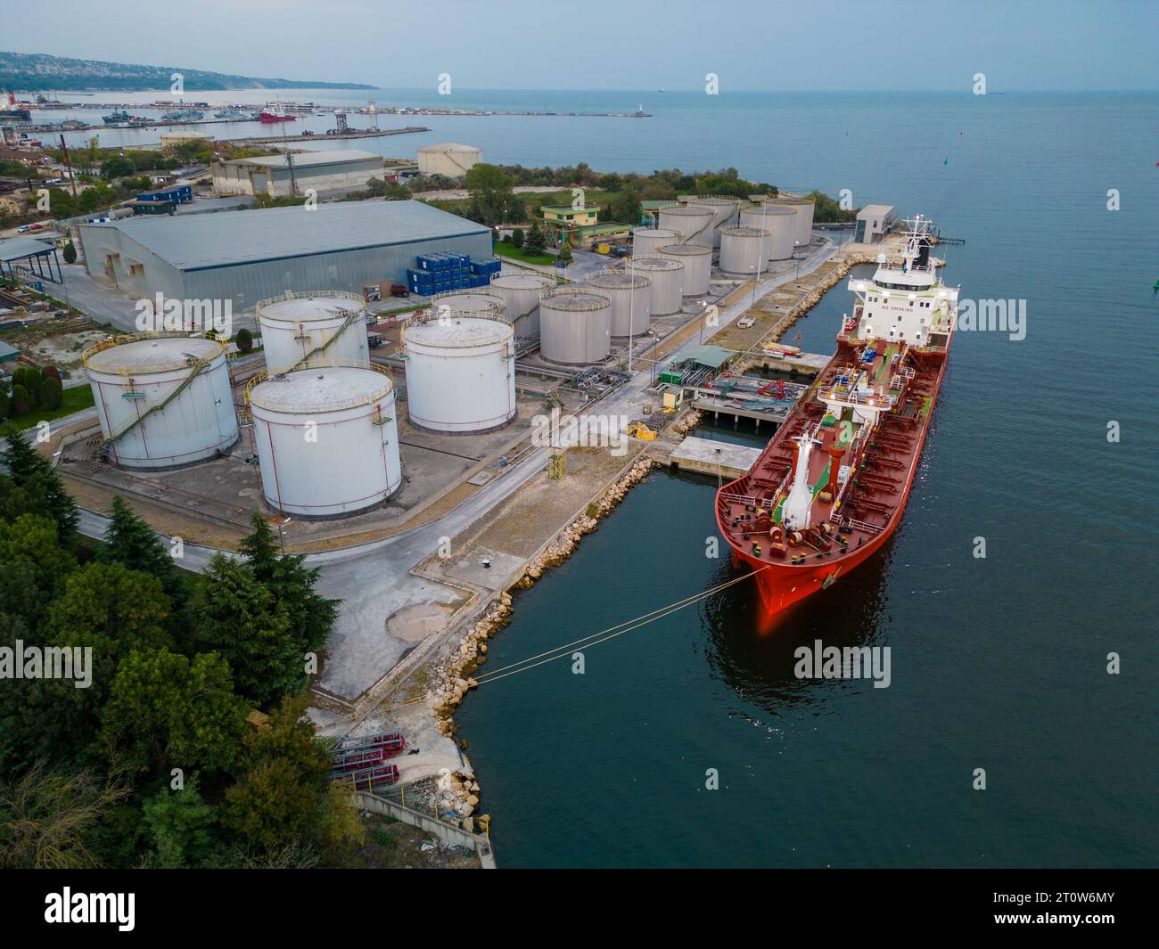 Tanker ship refueling at an oil terminal with storage silo's in the ...