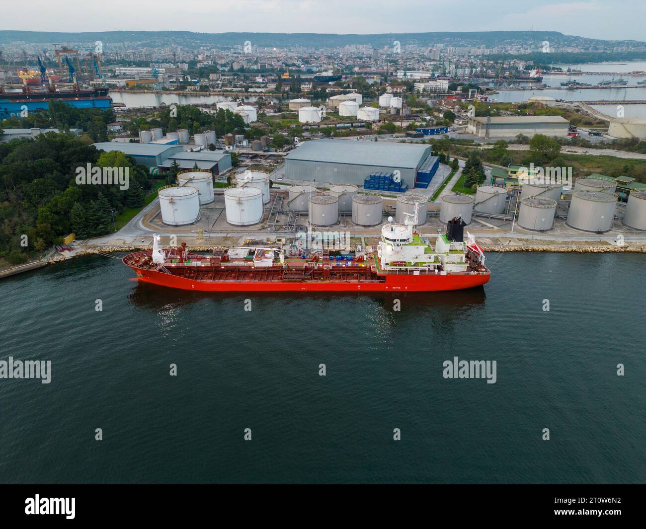 Tanker ship refueling at an oil terminal with storage silo's in the ...