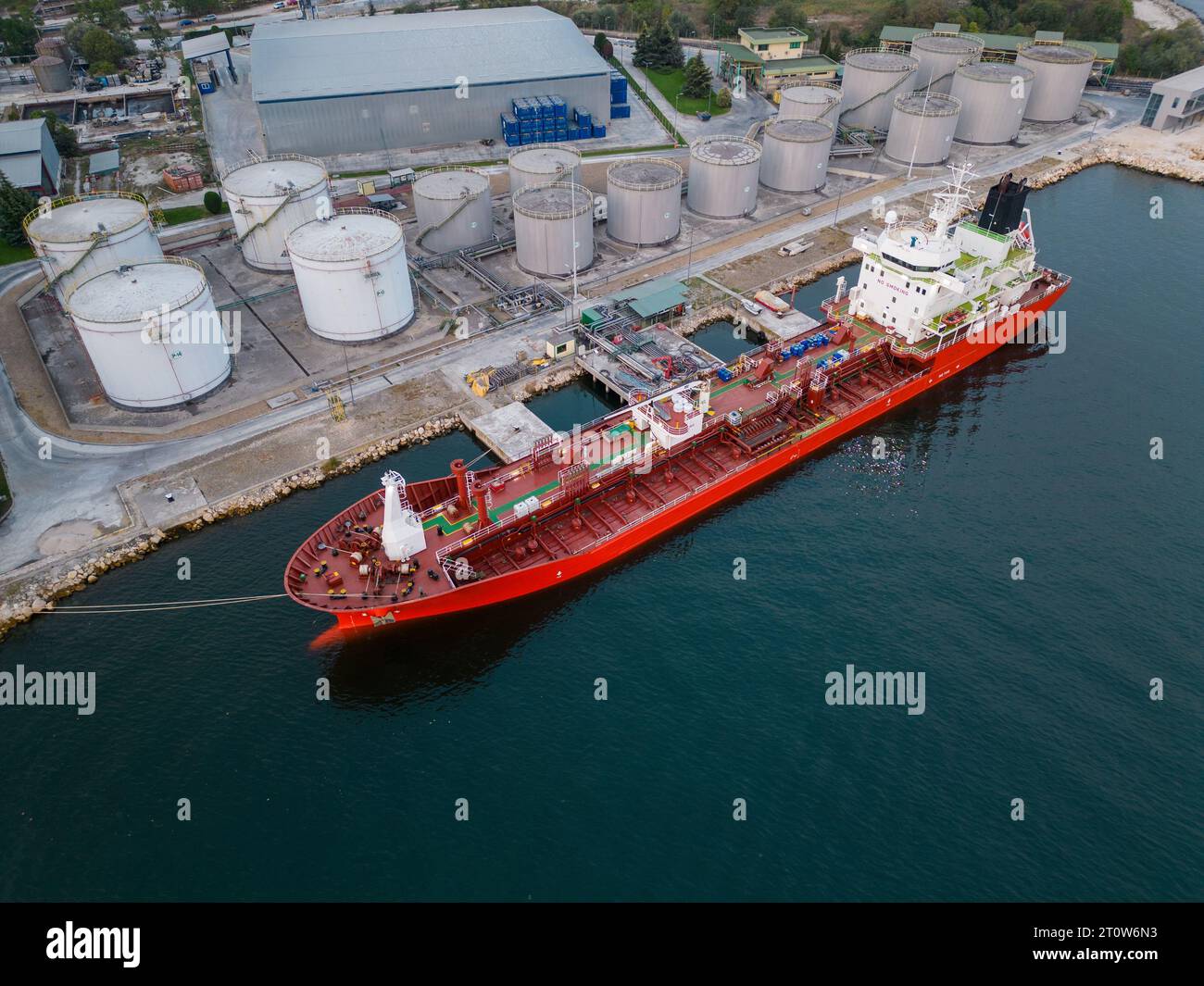 Tanker ship refueling at an oil terminal with storage silo's in the ...
