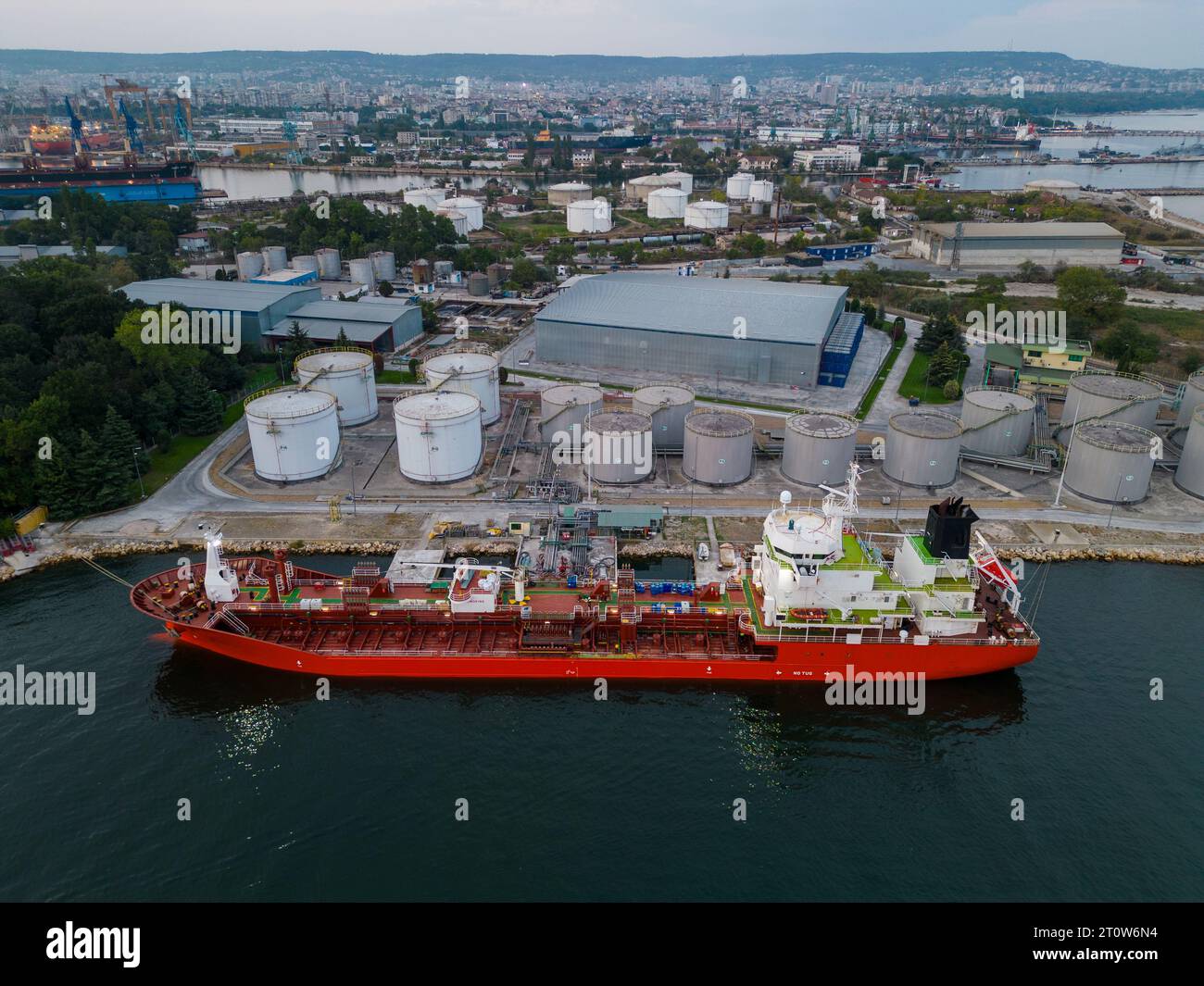 Tanker ship refueling at an oil terminal with storage silo's in the ...