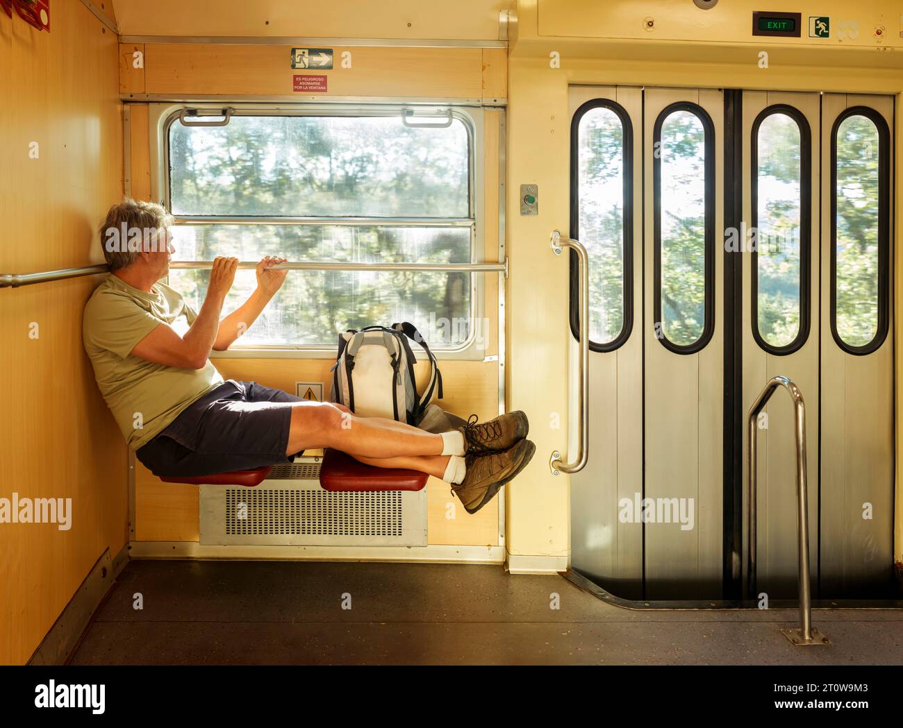 A middle-aged Caucasian traveller on a carriage of an antique train ...