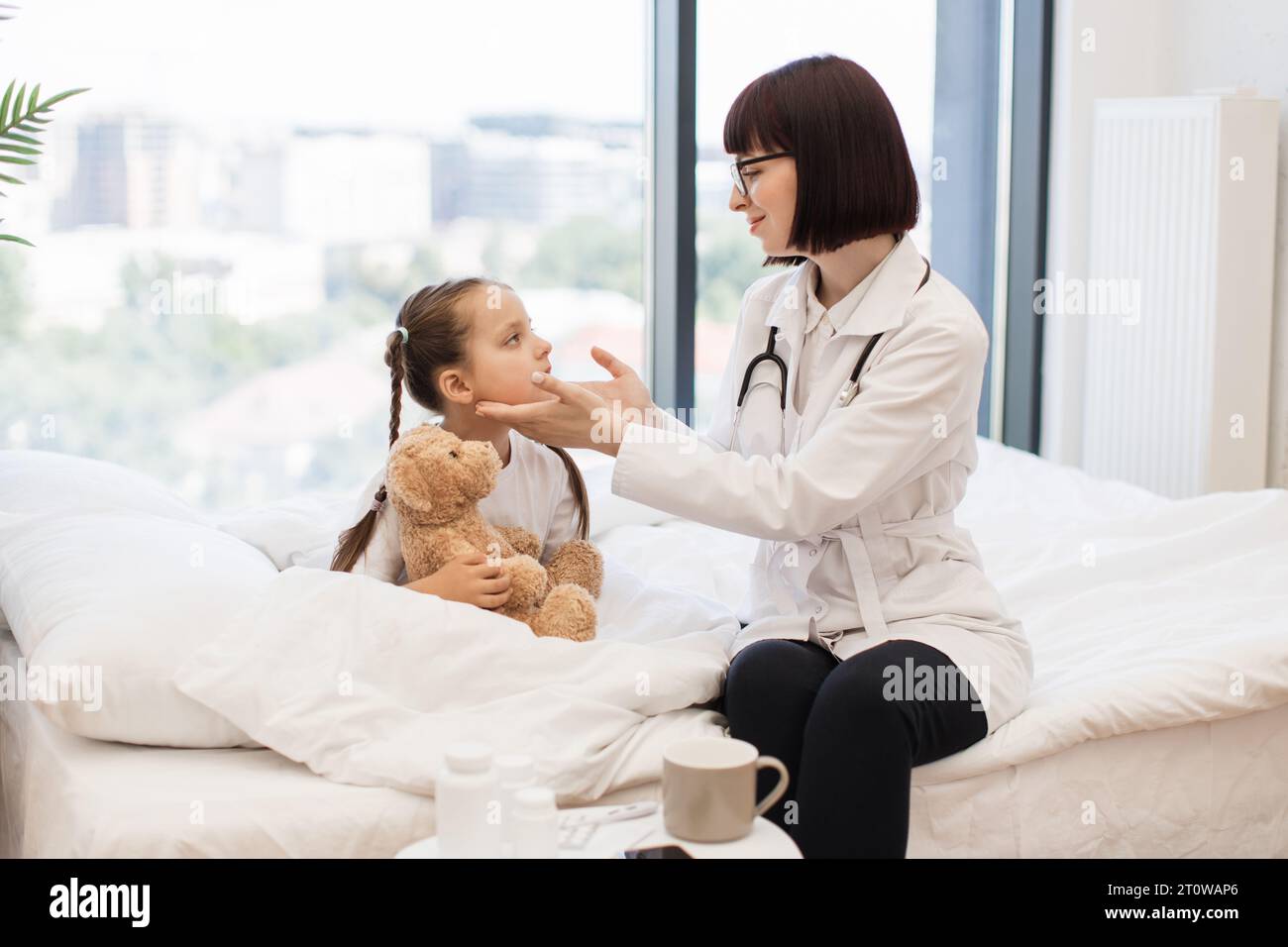 Female doctor checking lymph nodes of sick girl at home Stock Photo - Alamy