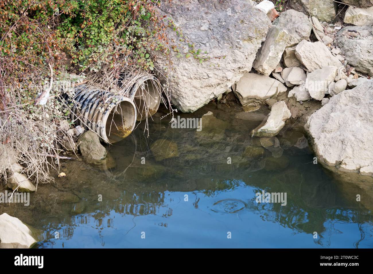 Plastic sewer pipes reaching out to the sea or lake water. Sewage ...