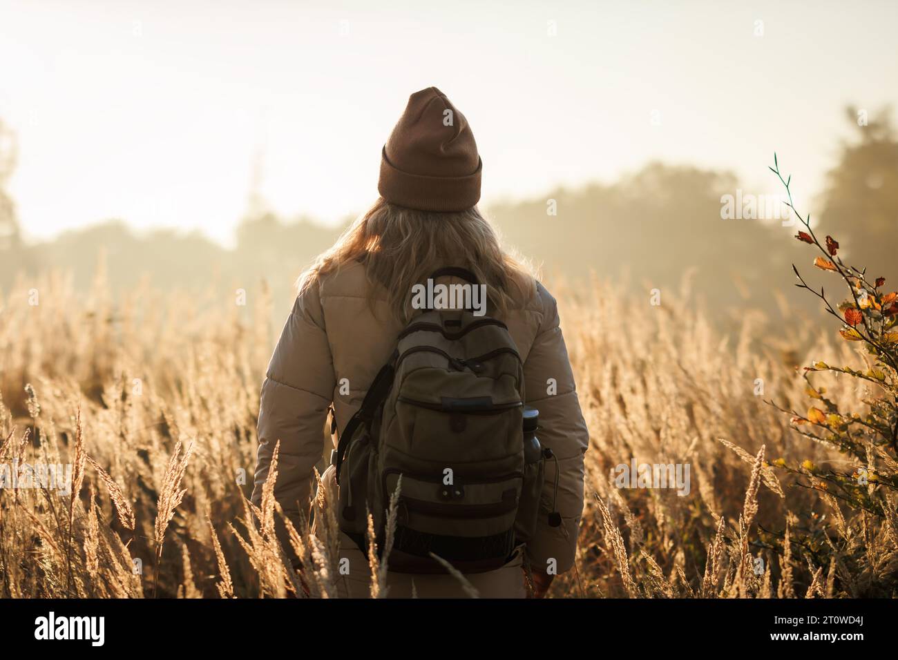 Misty cold morning and sunrise in autumn. Woman wearing warm clothing ...