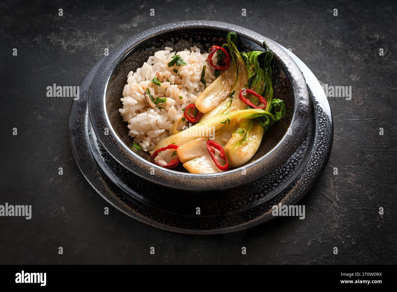 Pak choi (Chinese cabbage) with rice in a black ceramic bowl with ...