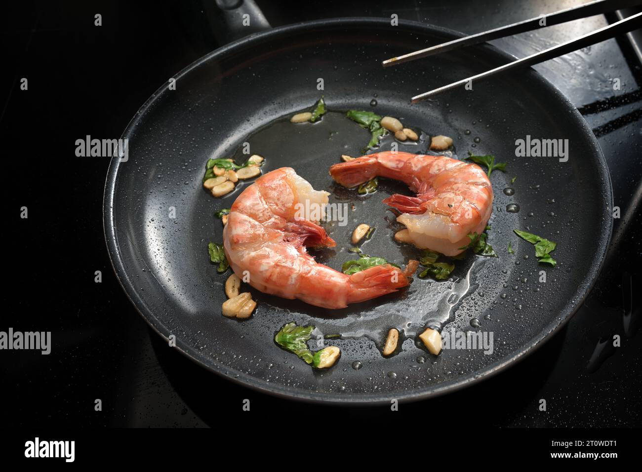 Two giant prawns are fried in olive oil with garlic and herbs in a ...