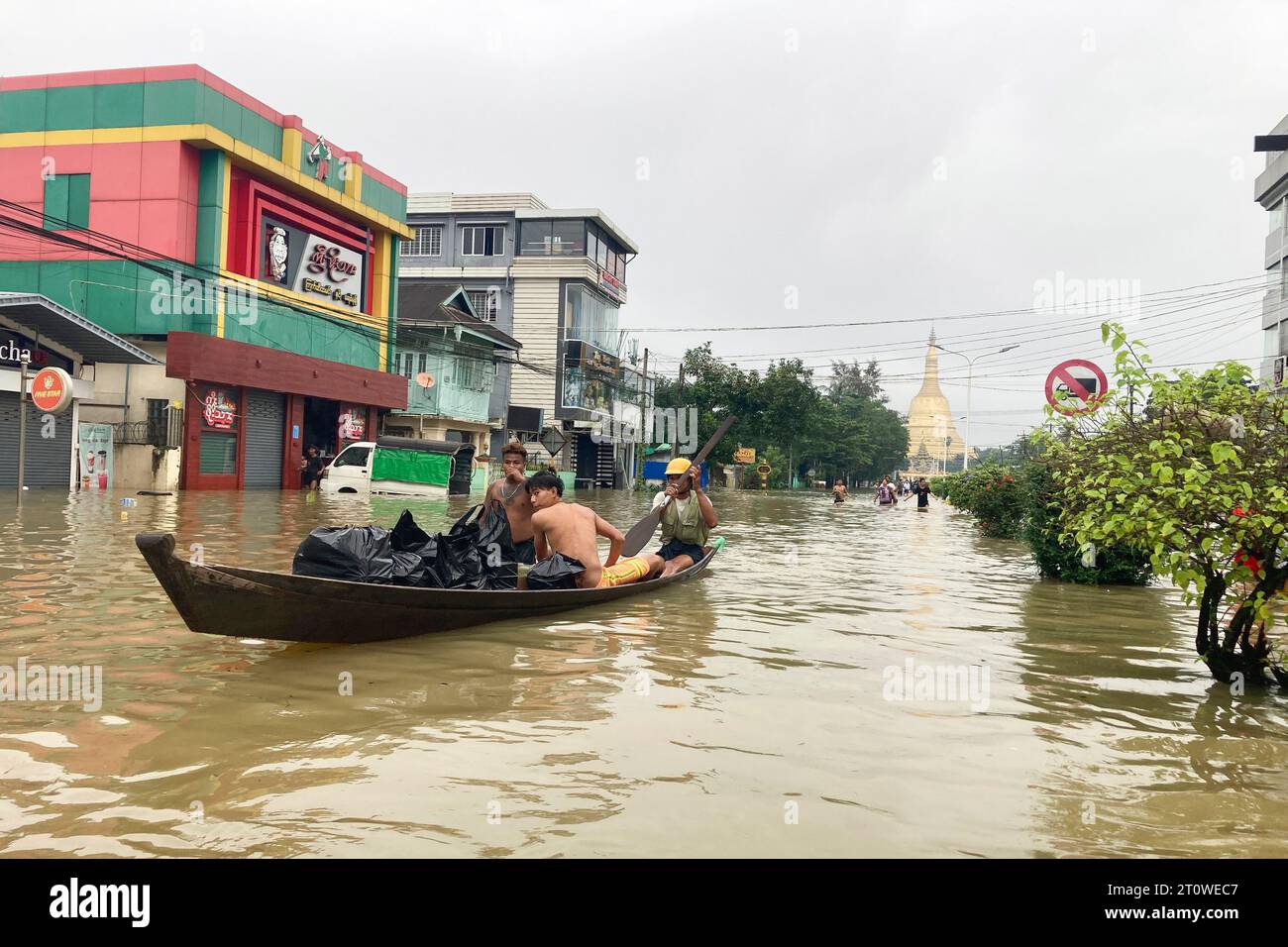 Local residents wade through a flooded road in Bago, about 80 ...