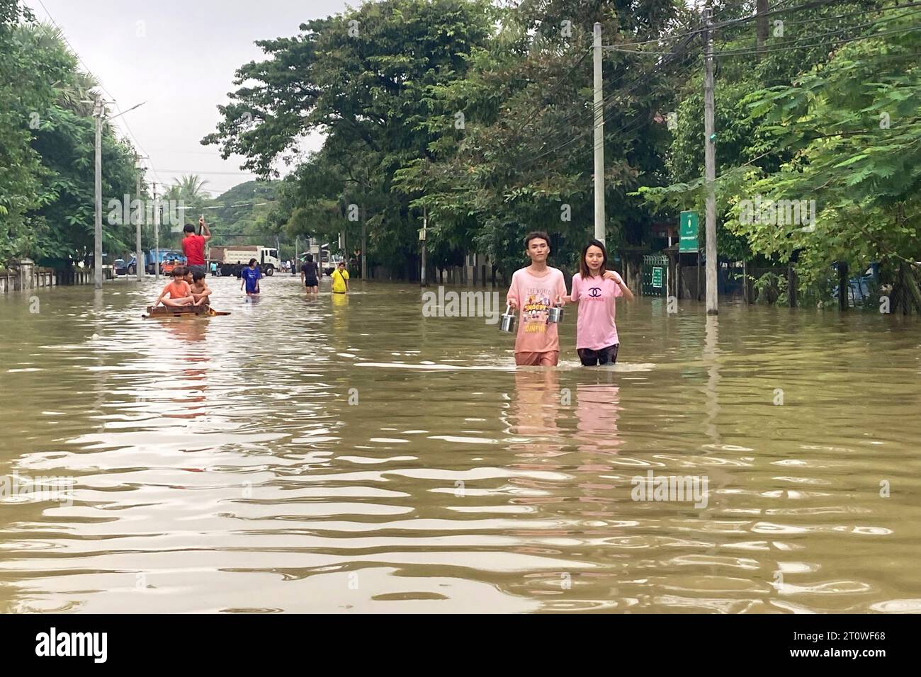 Local residents wade through a flooded road in Bago, about 80 ...