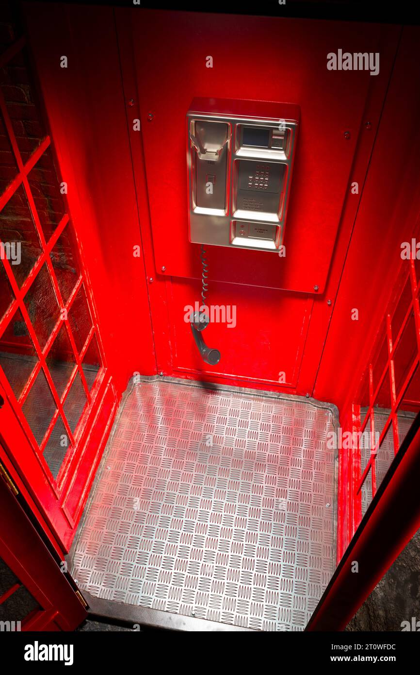 Black handset hanging in a red telephone box. Footage with a British ...