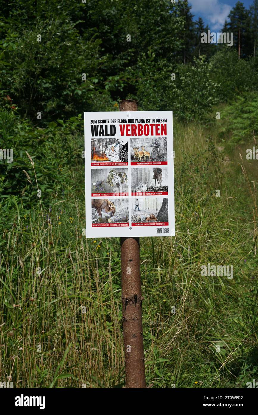 Prohibition sign in the forest with warning llustrationsand german Text ...