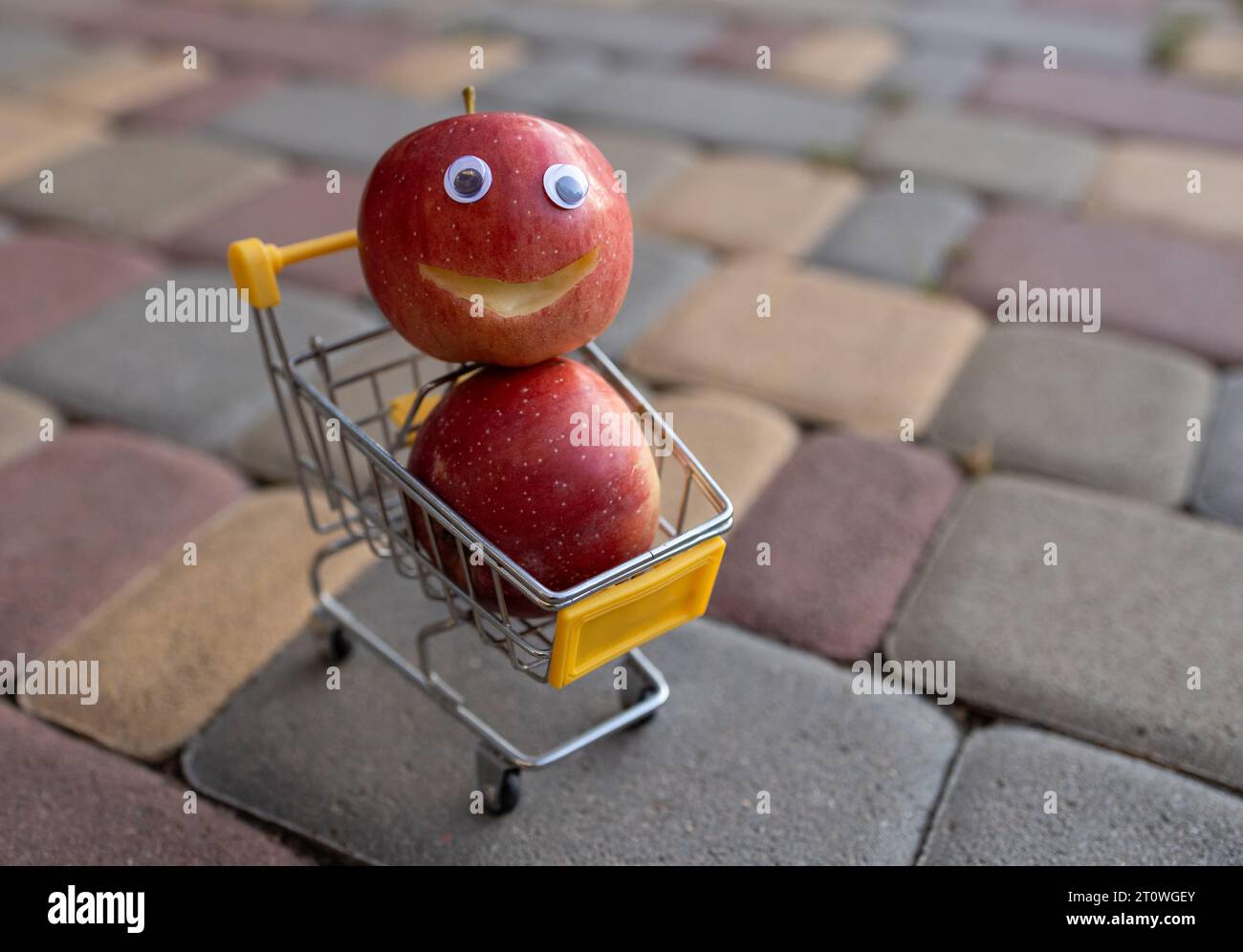 grocery cart with two red delicious apples, one with a smile cut out ...