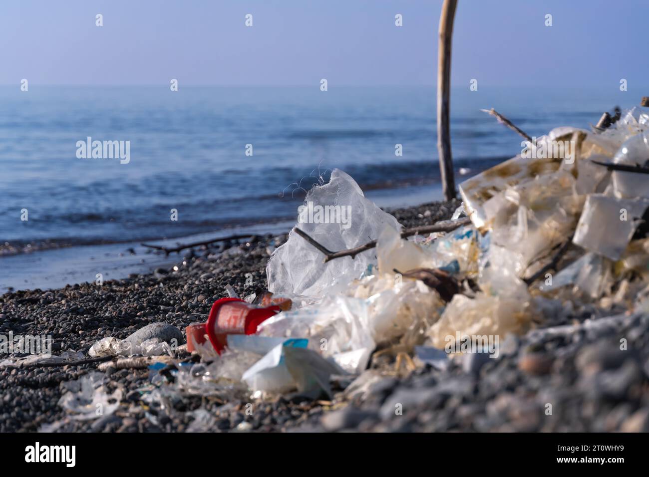 Close-up of a pile of garbage, cellophane on a pebble beach at sea on a ...