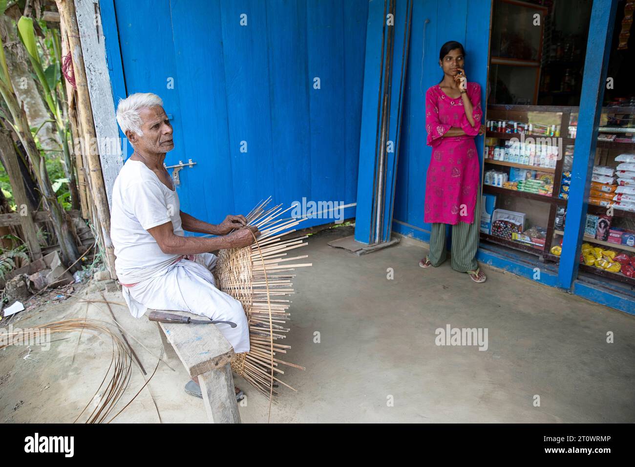 Local man infront of a blue coloured wooden wall making woven handmade ...
