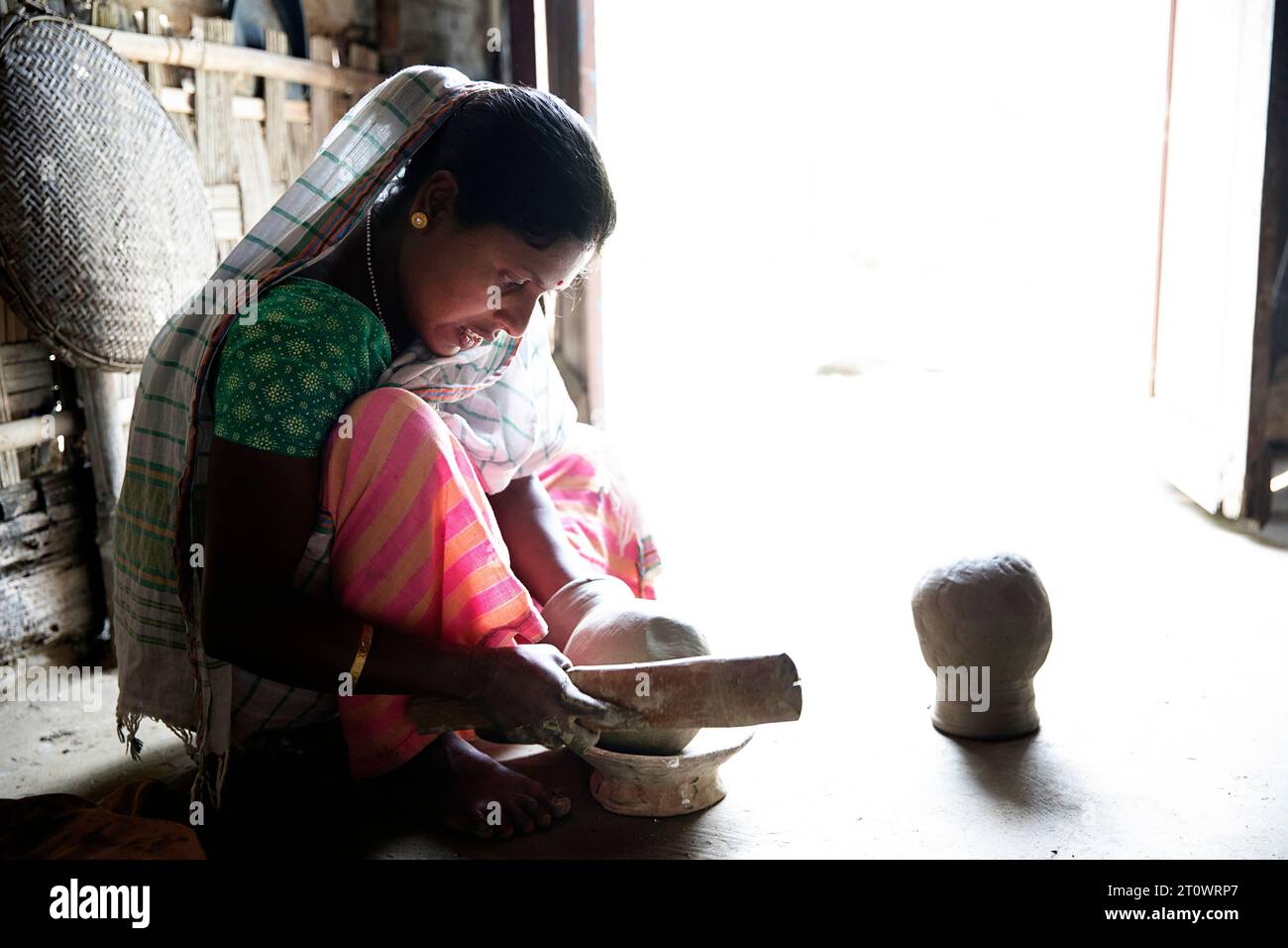 Woman in traditional indian clothes making pottery in his wooden house ...
