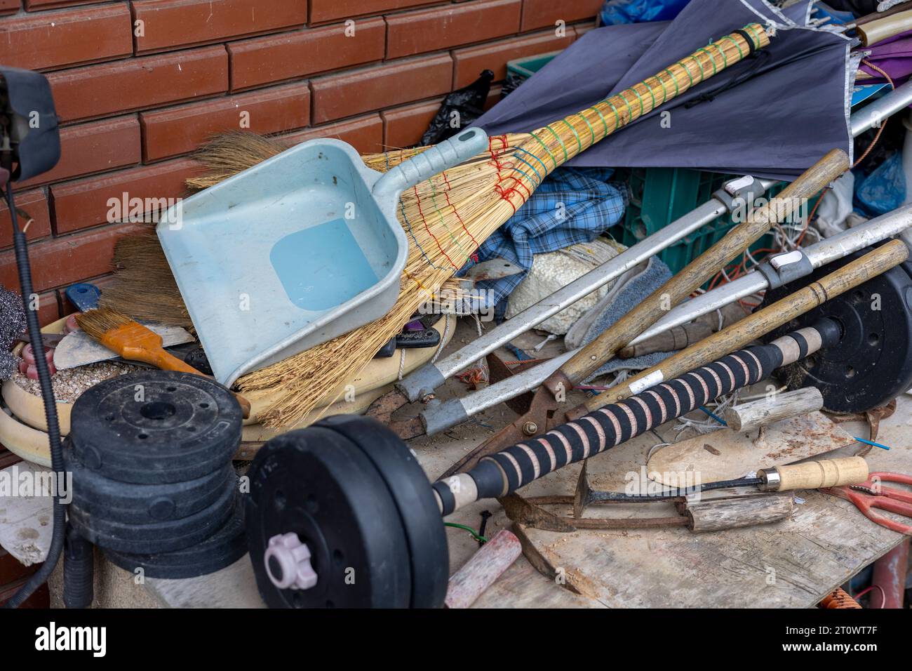 A warehouse piled with clutter such as cleaning tools and dumbbells ...