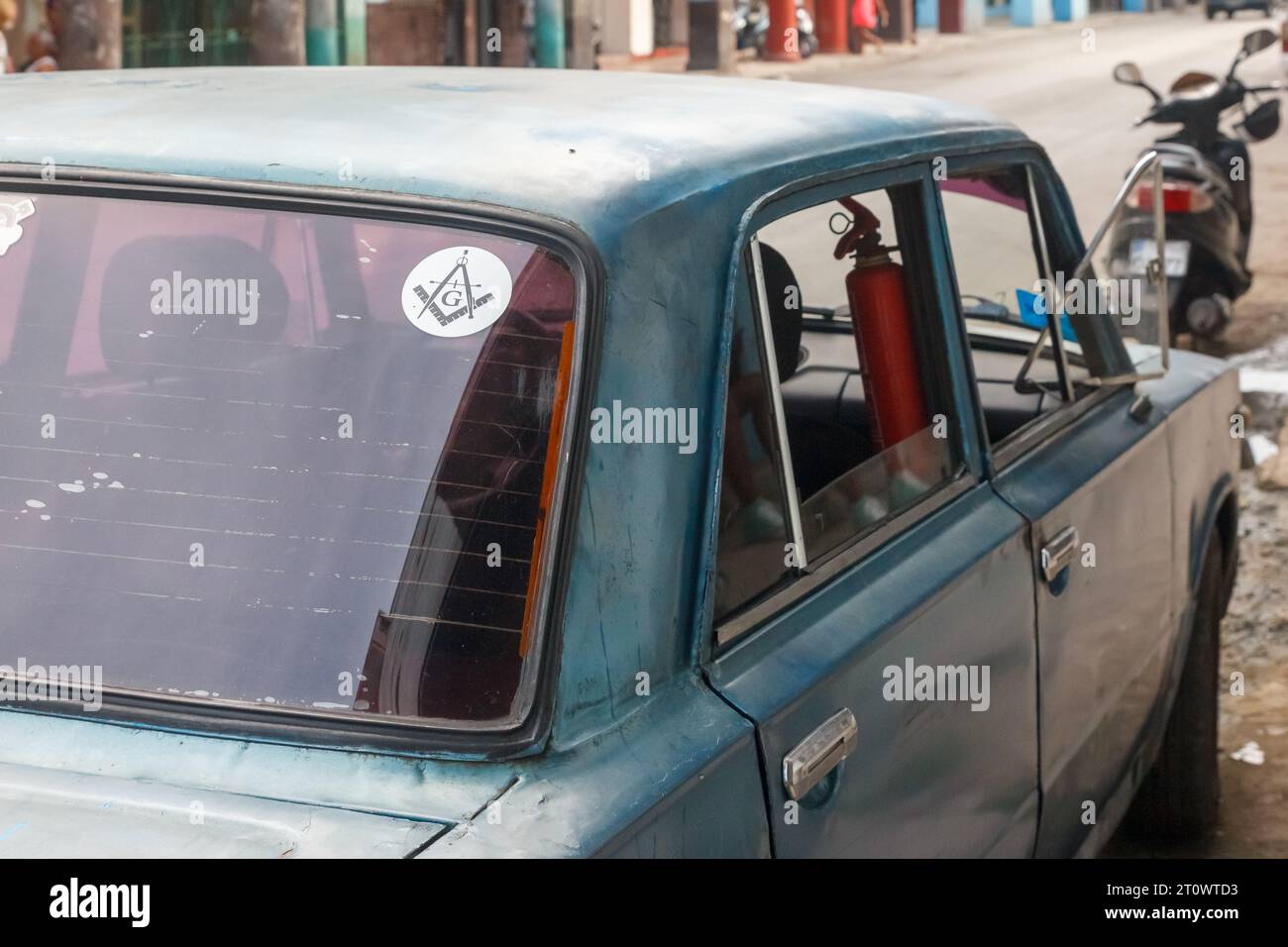 An old car with a Masonic logo in the rear windshield is parked in the ...