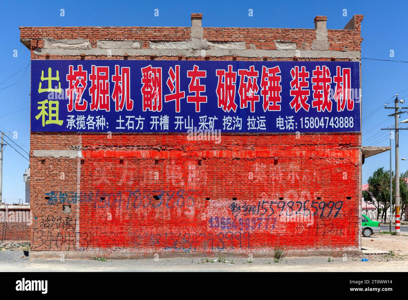 Building decorated by ads along a road in the Gegentala grasslands ...