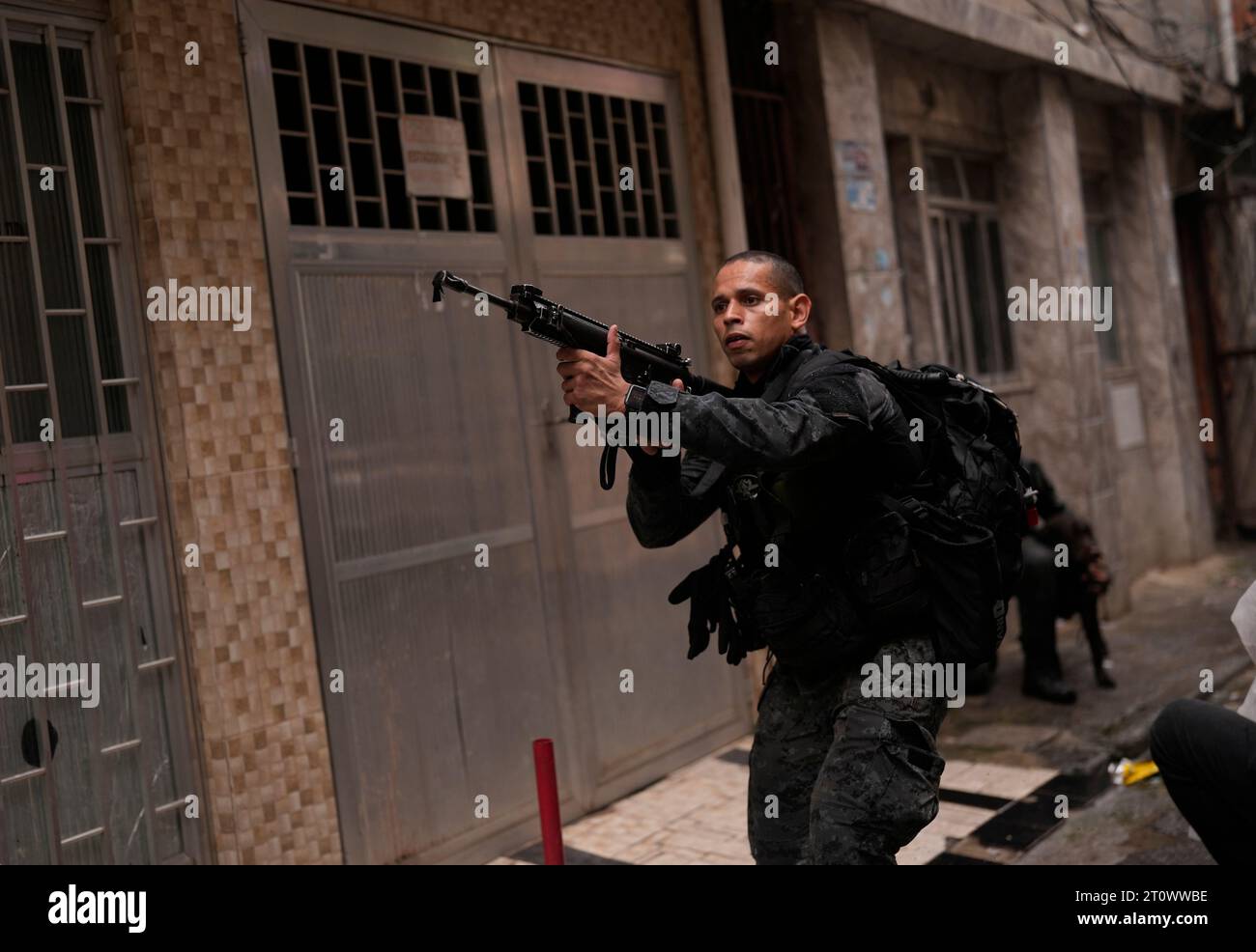 A police officers aims his weapon during a police operation against ...