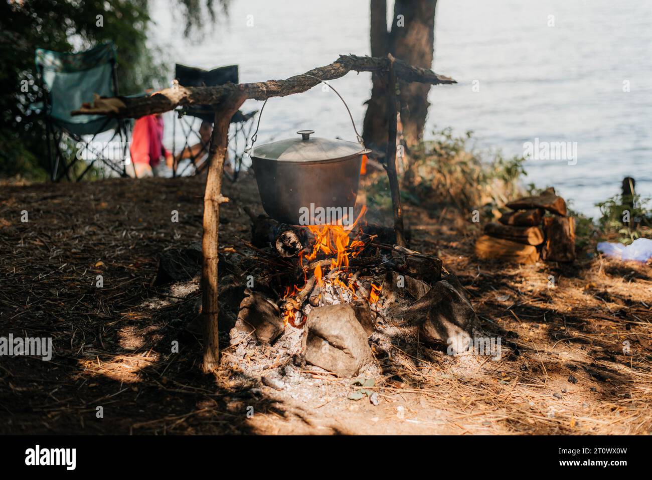Tourist pot hanging over the fire on a tripod. Cooking in the campaign ...