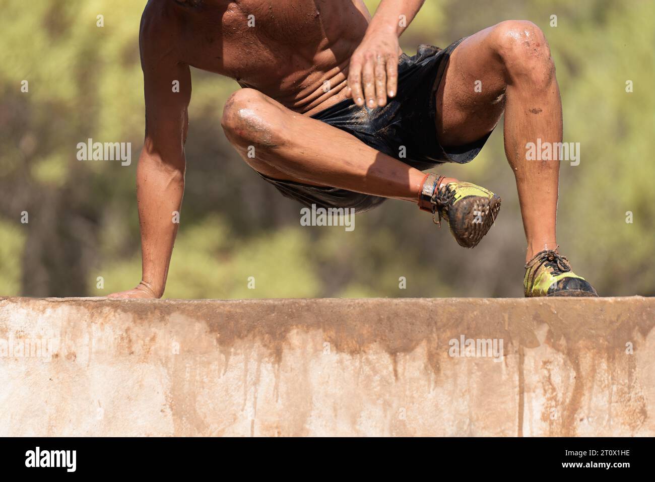 Mud race runners running over obstacles extreme sport Stock Photo - Alamy