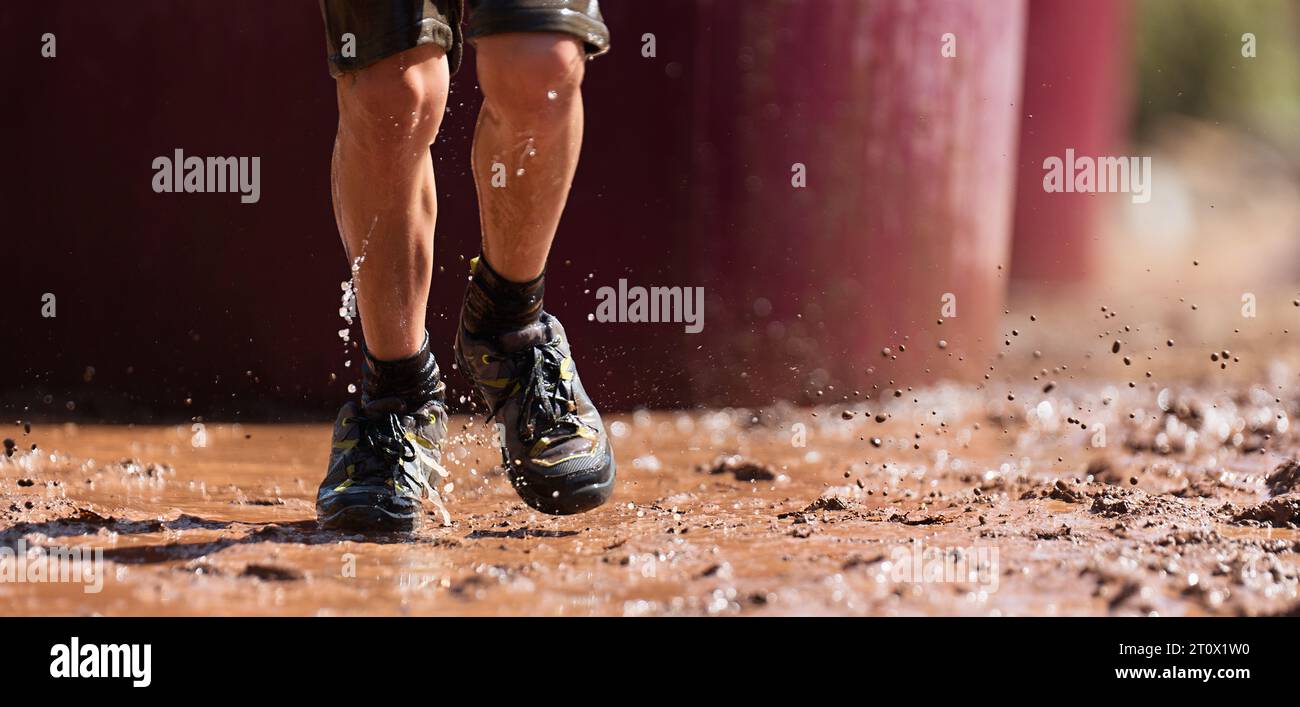 Mud race runners. Overcoming a water obstacle during extreme obstacle ...