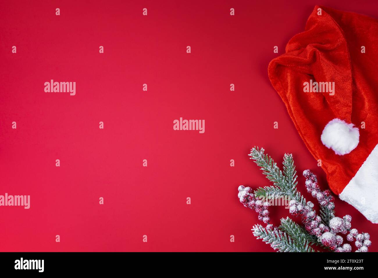 Red Santa Claus hat, Christmas tree branch on red surface. Christmas ...