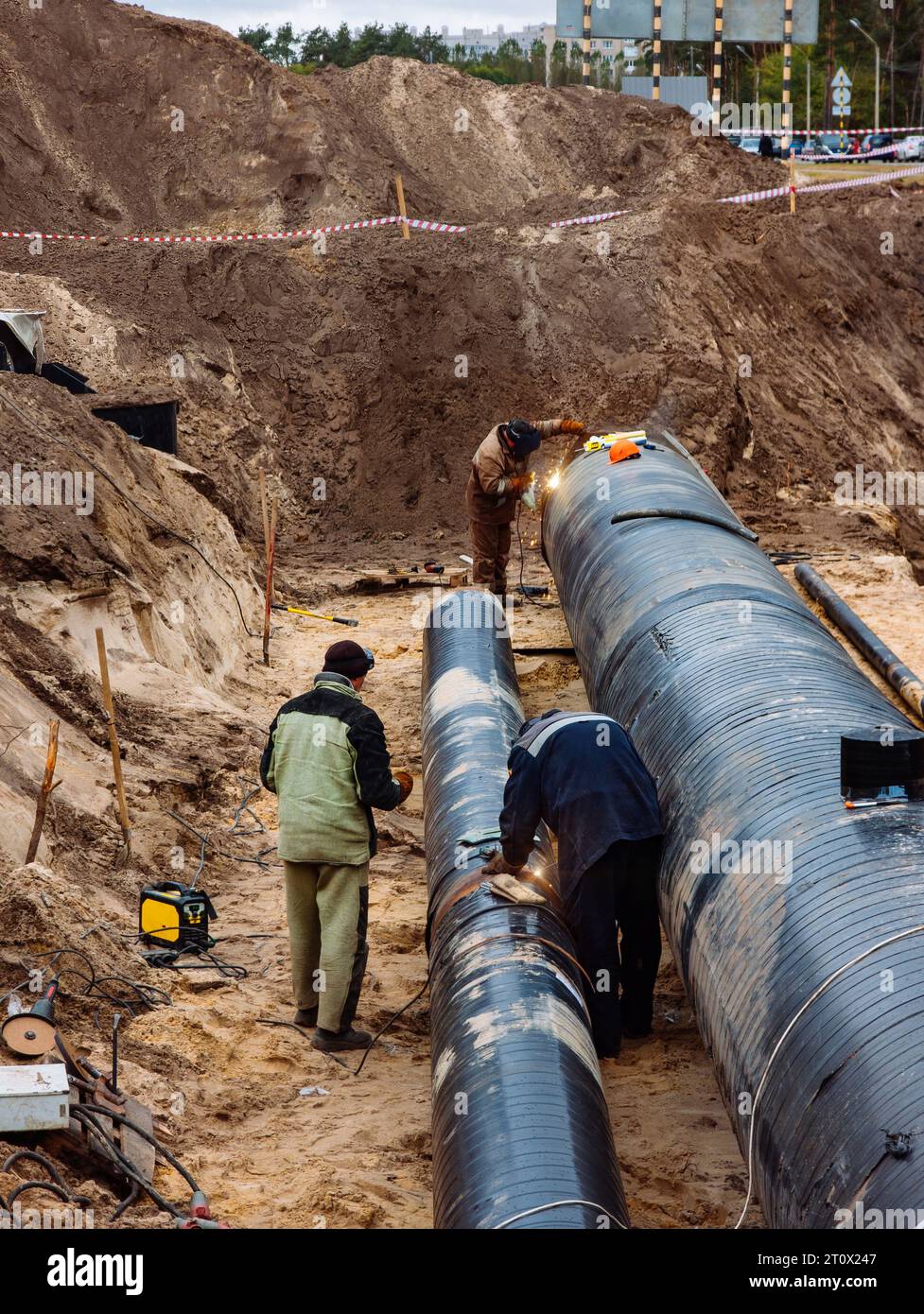 Workers in protective mask welding water supply pipes Stock Photo - Alamy